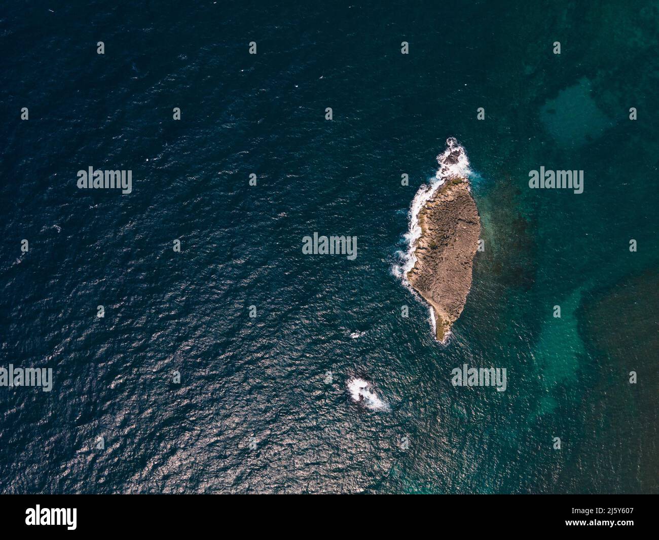 Drone view of rough rocky desolate island washed by waves located in ...