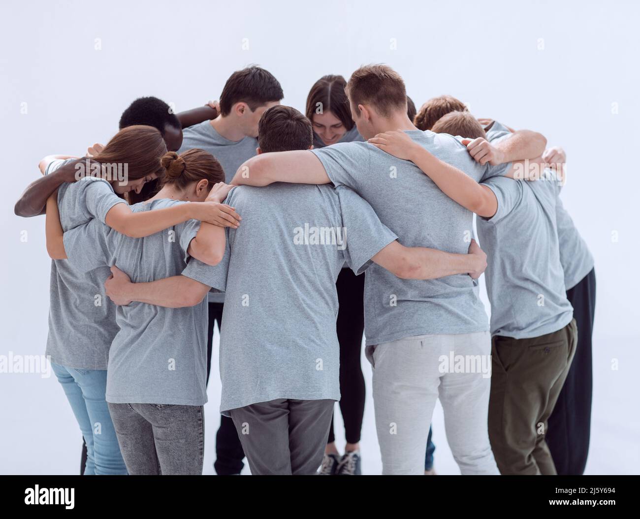 group of young people standing in a circle and hugging each other ...