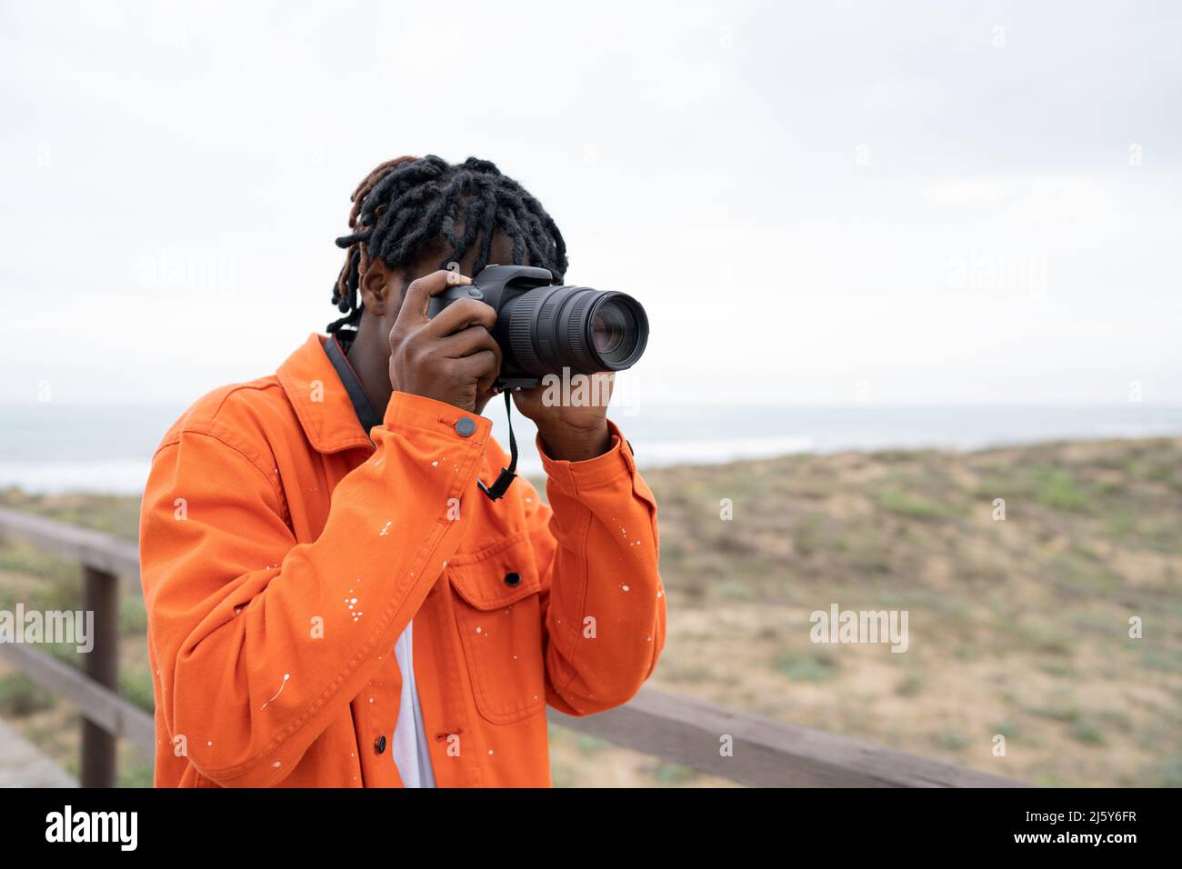 Focused African American male photographer taking picture on ...