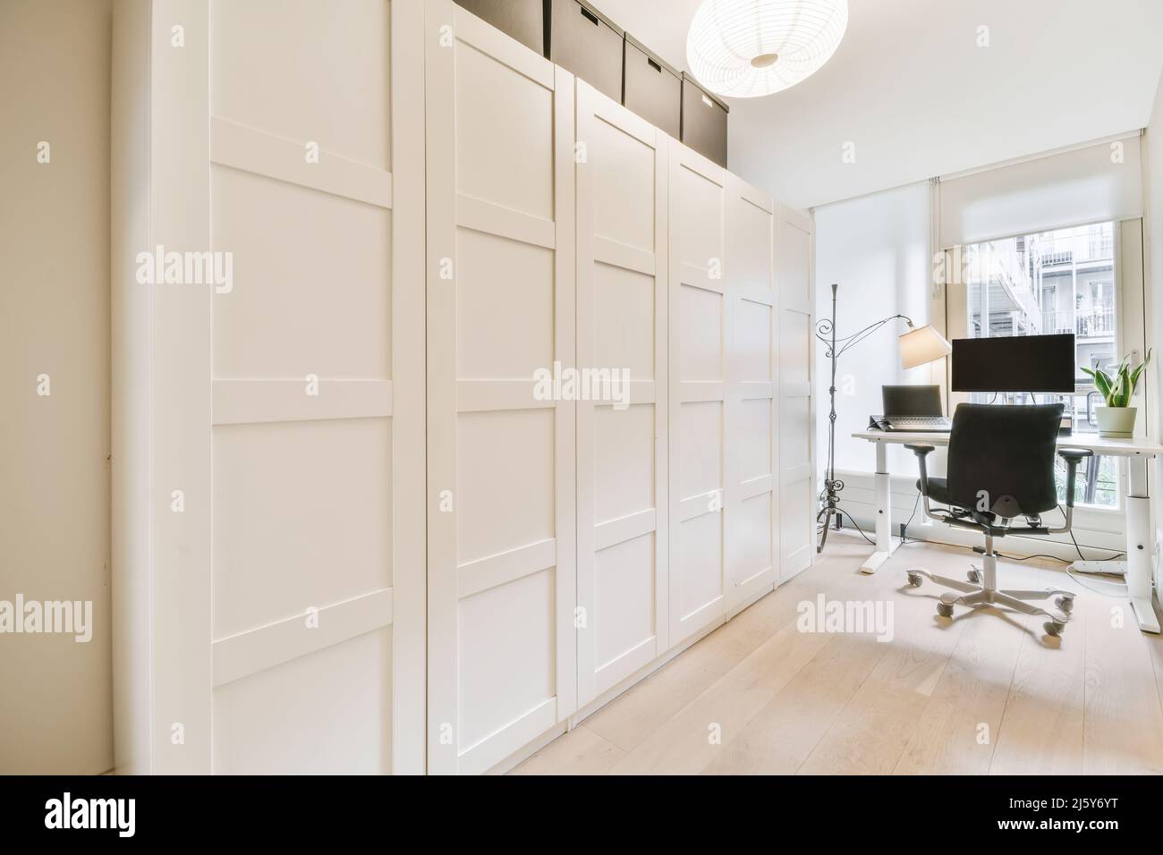 Laptop and computer placed on table near window in light stylish home ...