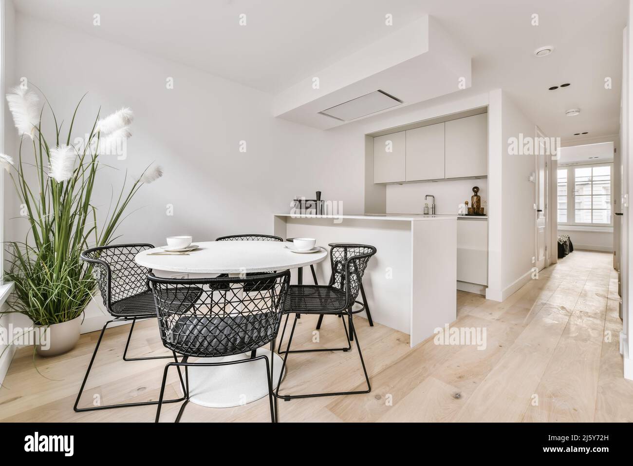 Dining table with crockery and cutlery in light living room near ...