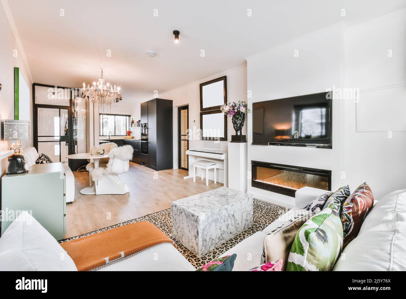 Comfortable sofa with colorful cushions placed near wall with fireplace ...