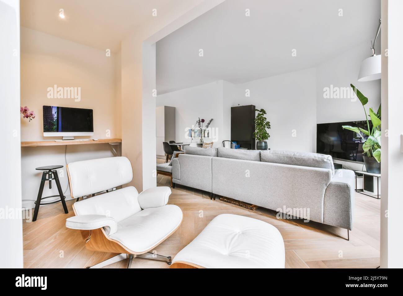 Comfortable armchair and table with computer placed behind soft couch ...