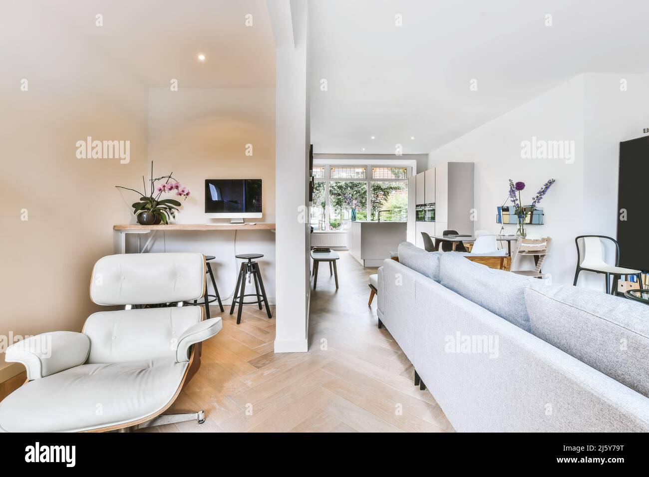 Comfortable armchair and table with computer placed behind soft couch ...