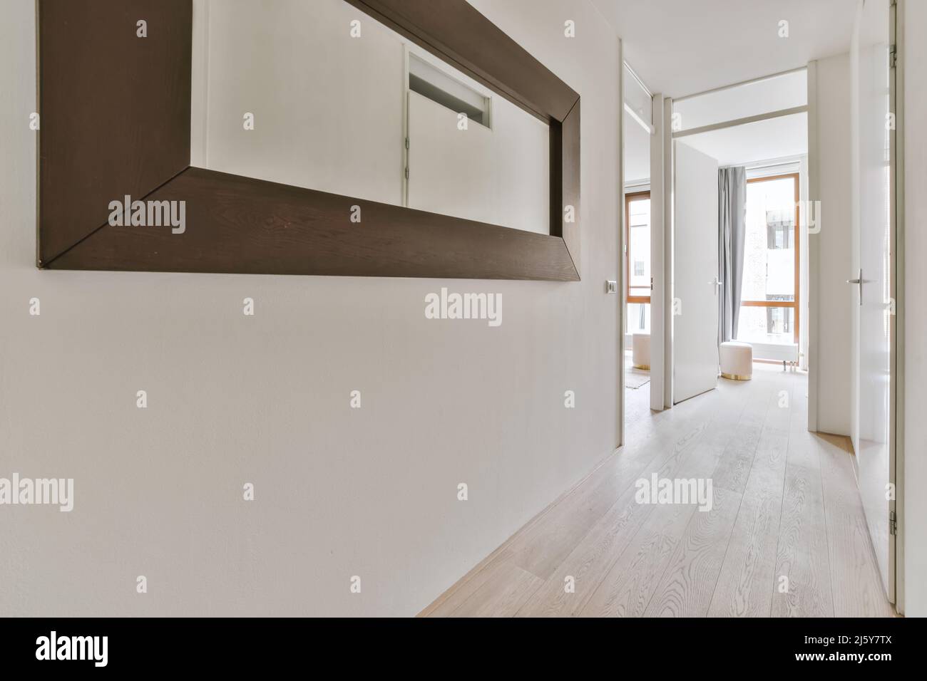 Stylish rectangular shaped mirror hanging on white wall in light ...