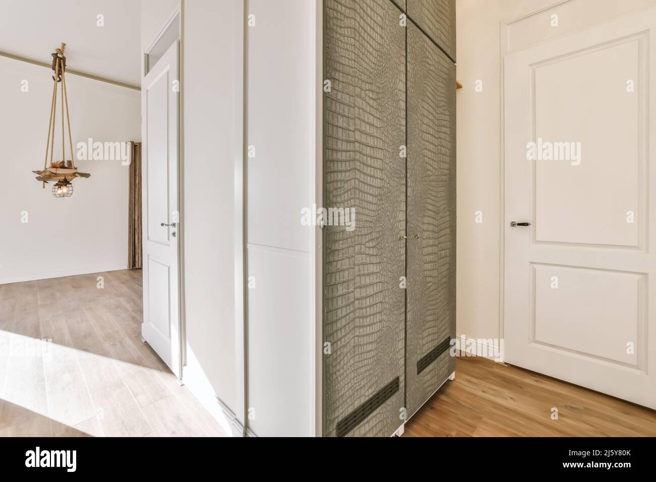 Stylish corridor with white walls and modern wardrobe with laminated ...