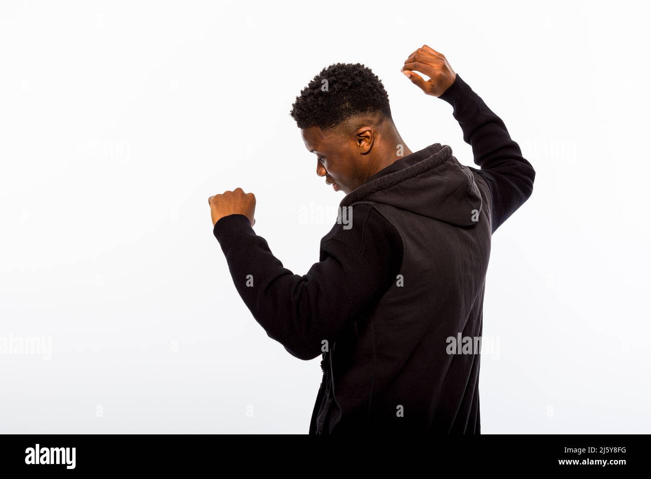 Side view of African American guy in black hoodie looking down while ...