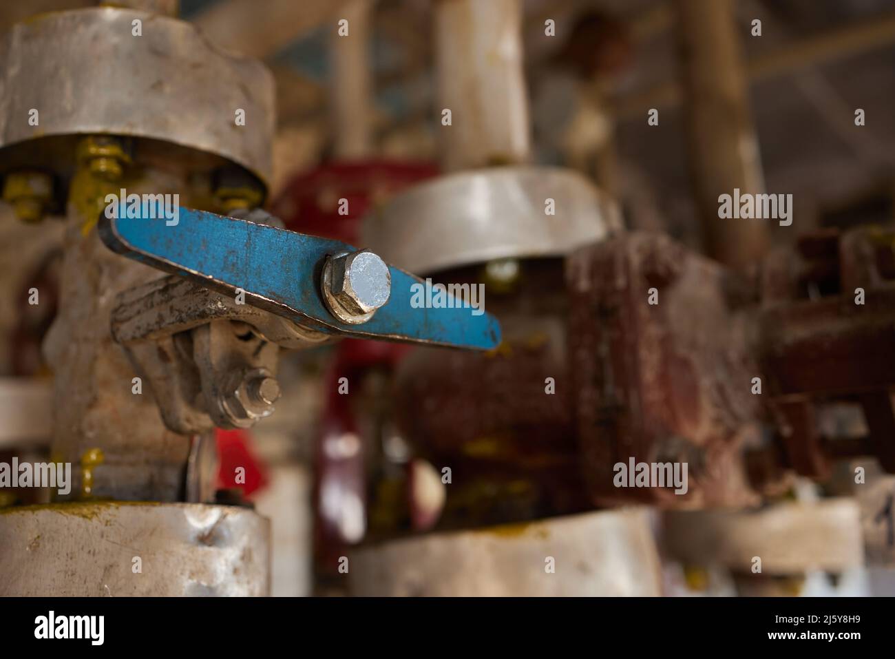 Close-up at pipeline valve which is using to control production process ...