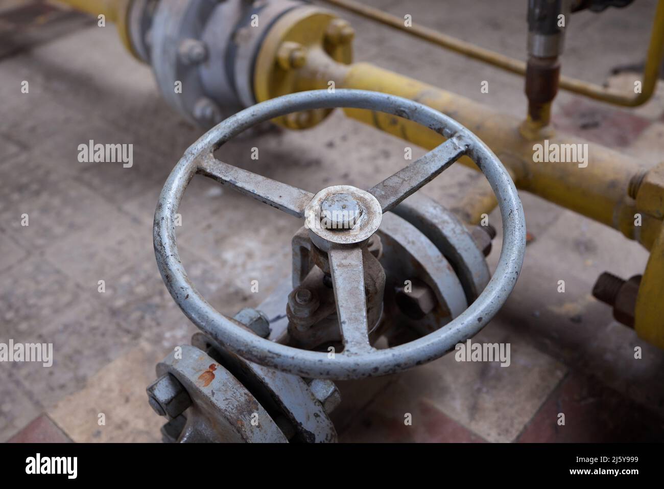 Close-up at pipeline valve which is using to control production process ...