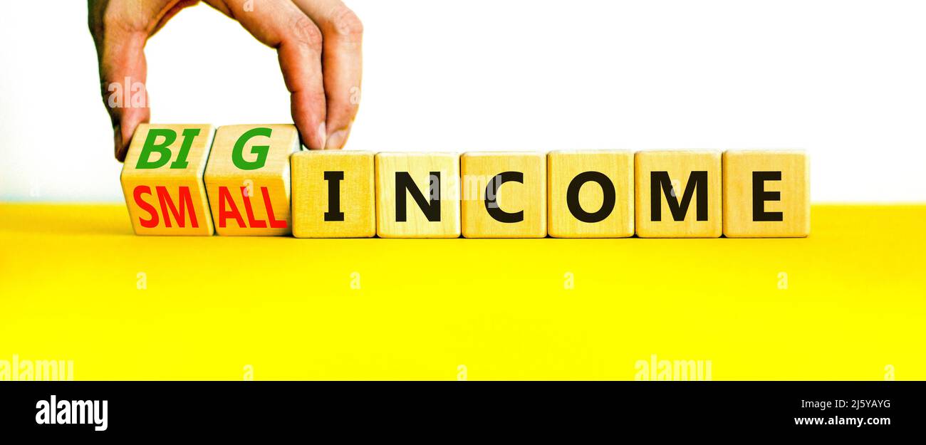 Big or small income symbol. Businessman turns wooden cubes and changes ...
