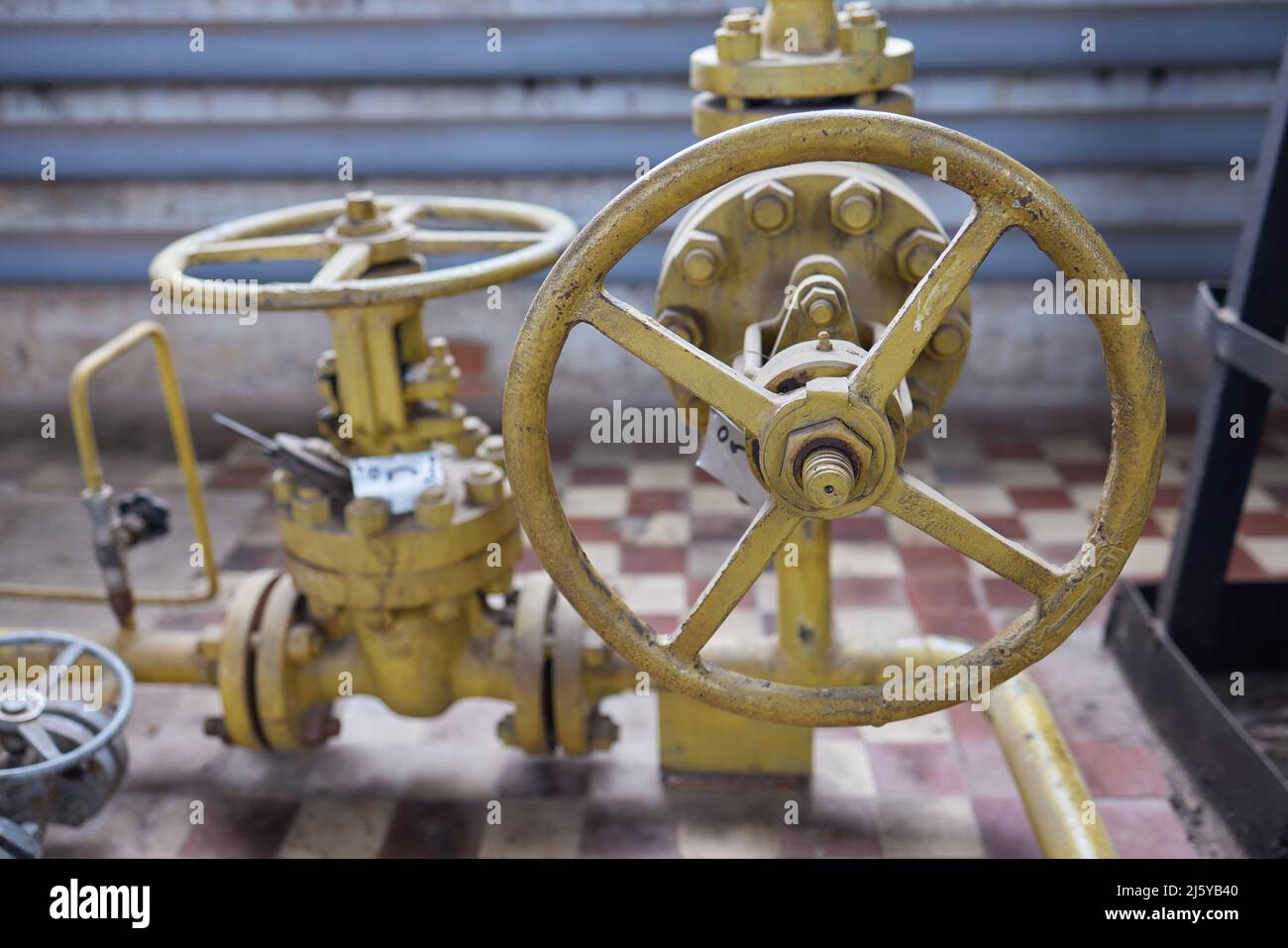 Close-up at pipeline valve which is using to control production process ...