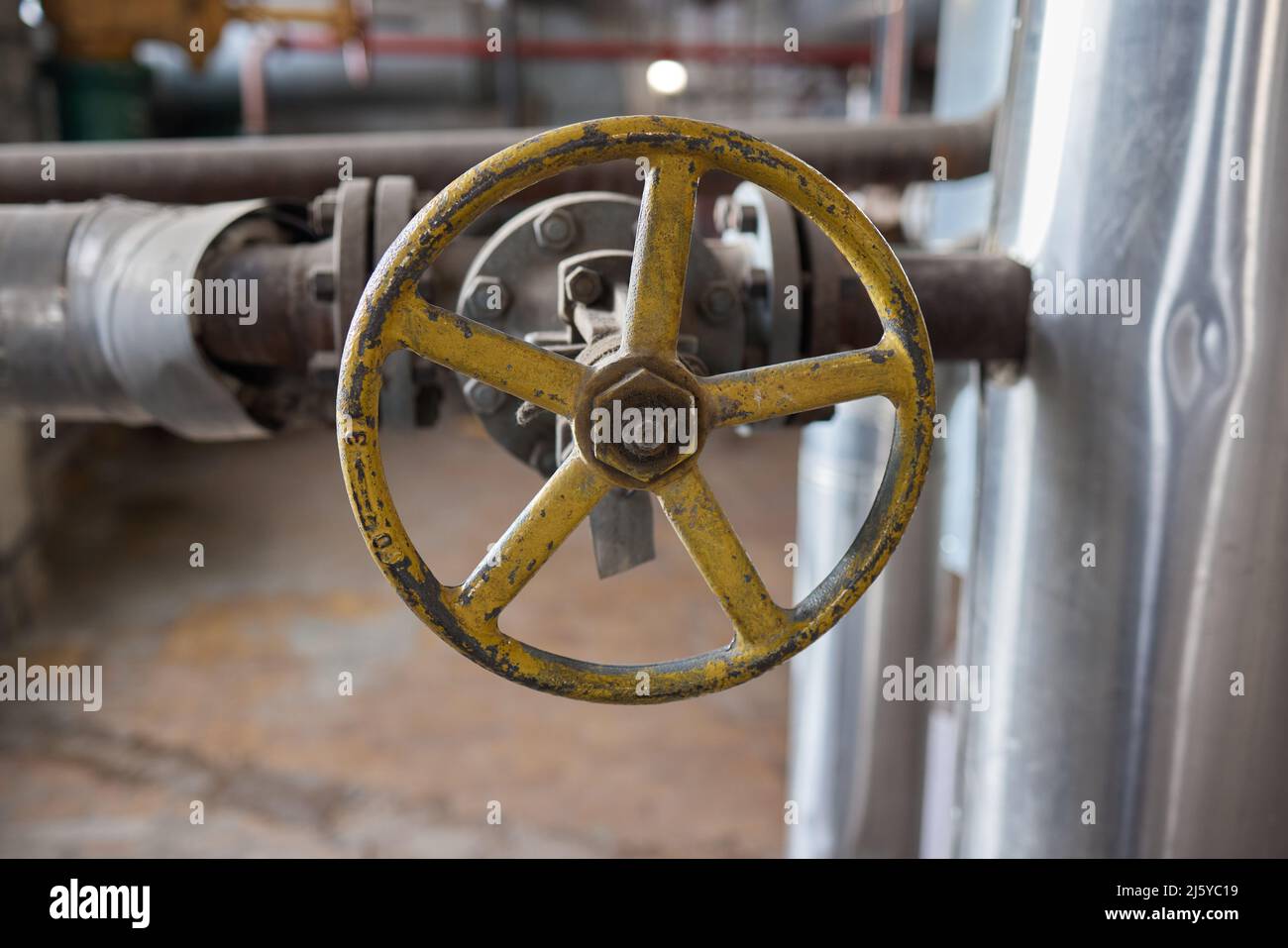 Close-up at pipeline valve which is using to control production process ...