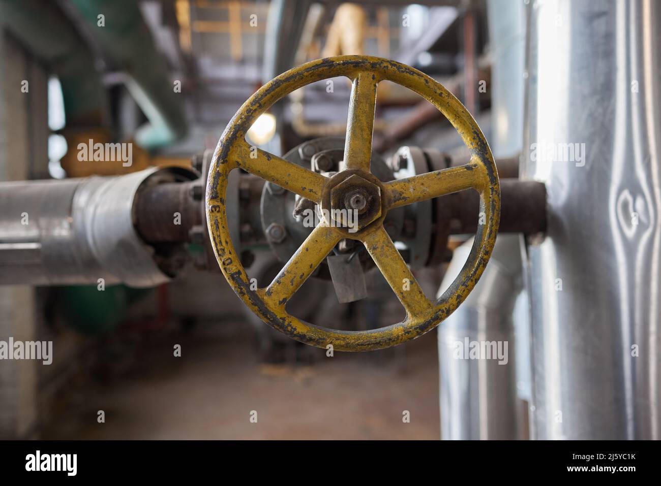 Close-up at pipeline valve which is using to control production process ...