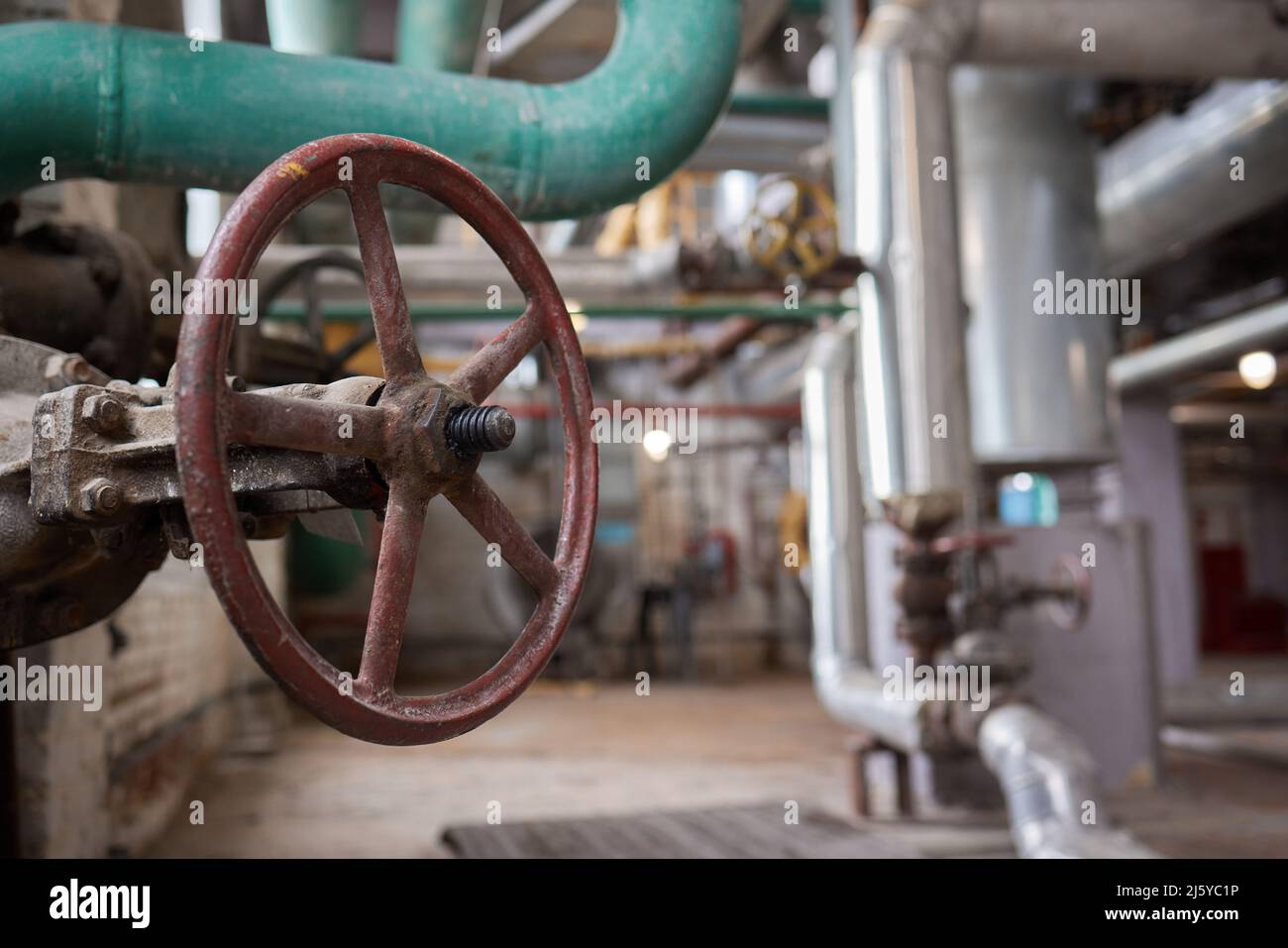 Close-up at pipeline valve which is using to control production process ...