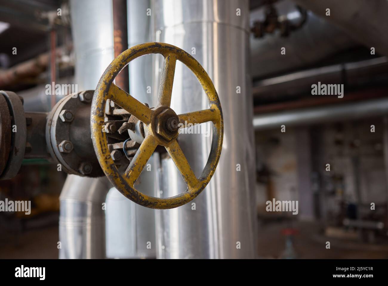 Close-up at pipeline valve which is using to control production process ...