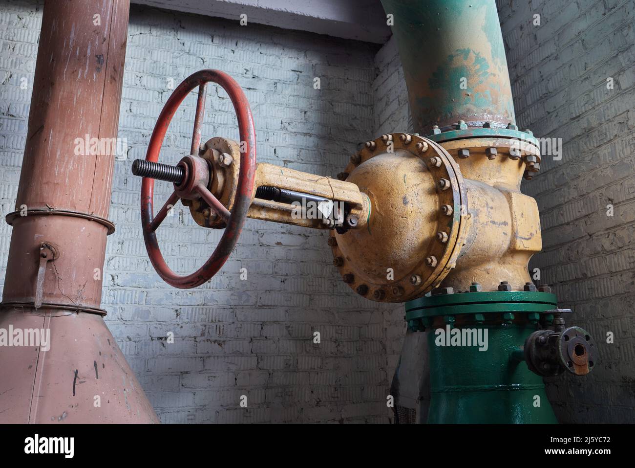Close-up at pipeline valve which is using to control production process ...