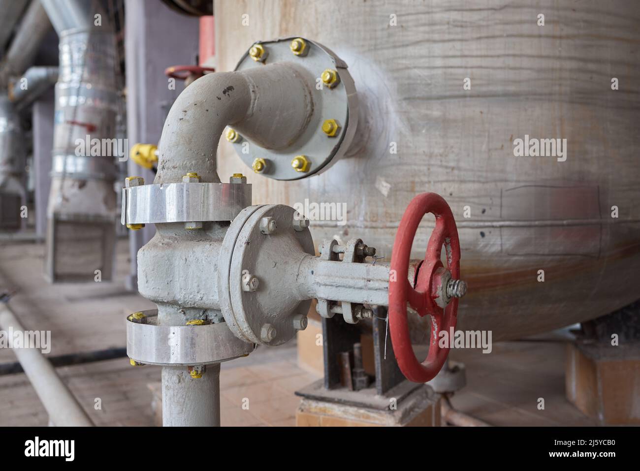 Close-up at pipeline valve which is using to control production process ...