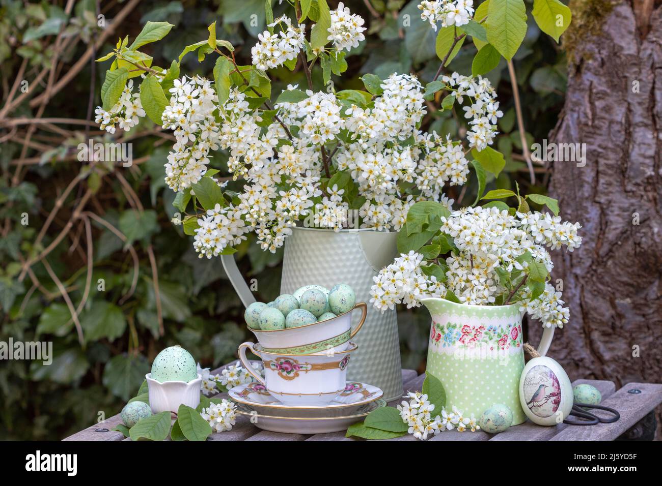 romantic easter decoration with easter eggs and bouquet of bird cherry ...