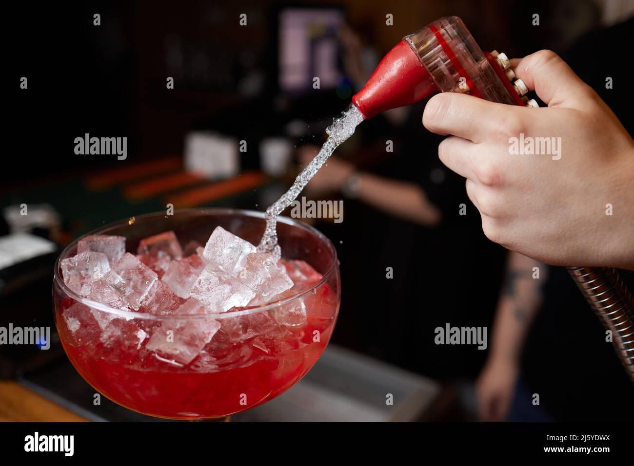 Bartender is making cocktail at bar counter at night club, Close Up. Concept about service and ...