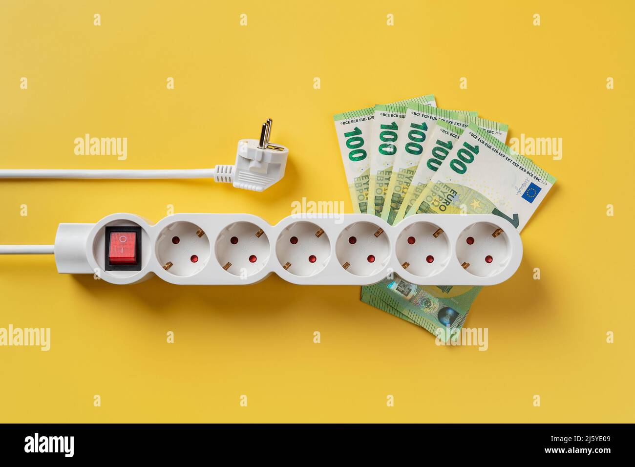 White power strip on 100 euro banknotes and white electric plug over ...