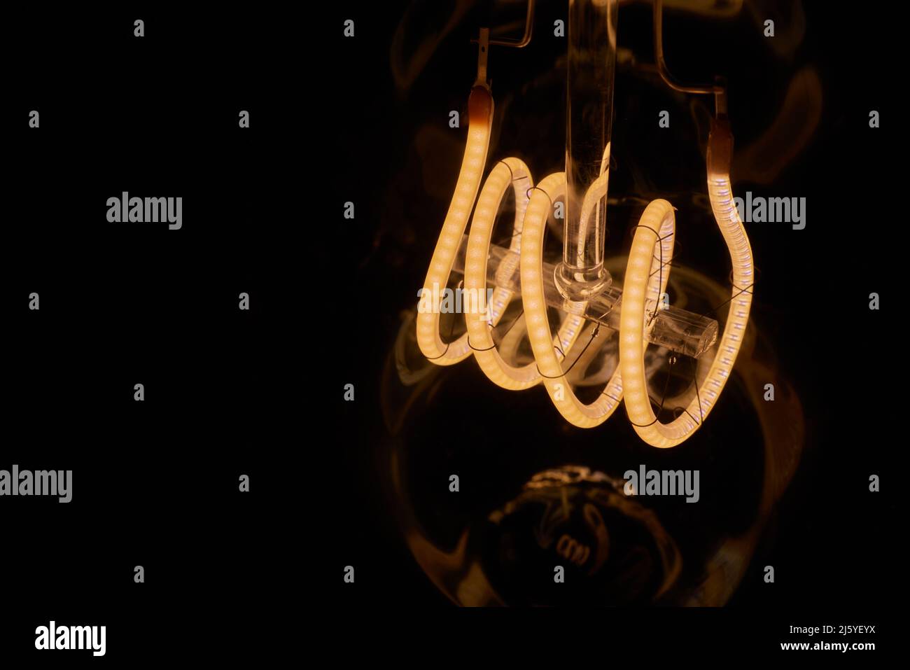 long tube-shaped Edison lamp, bulb, black background Stock Photo - Alamy