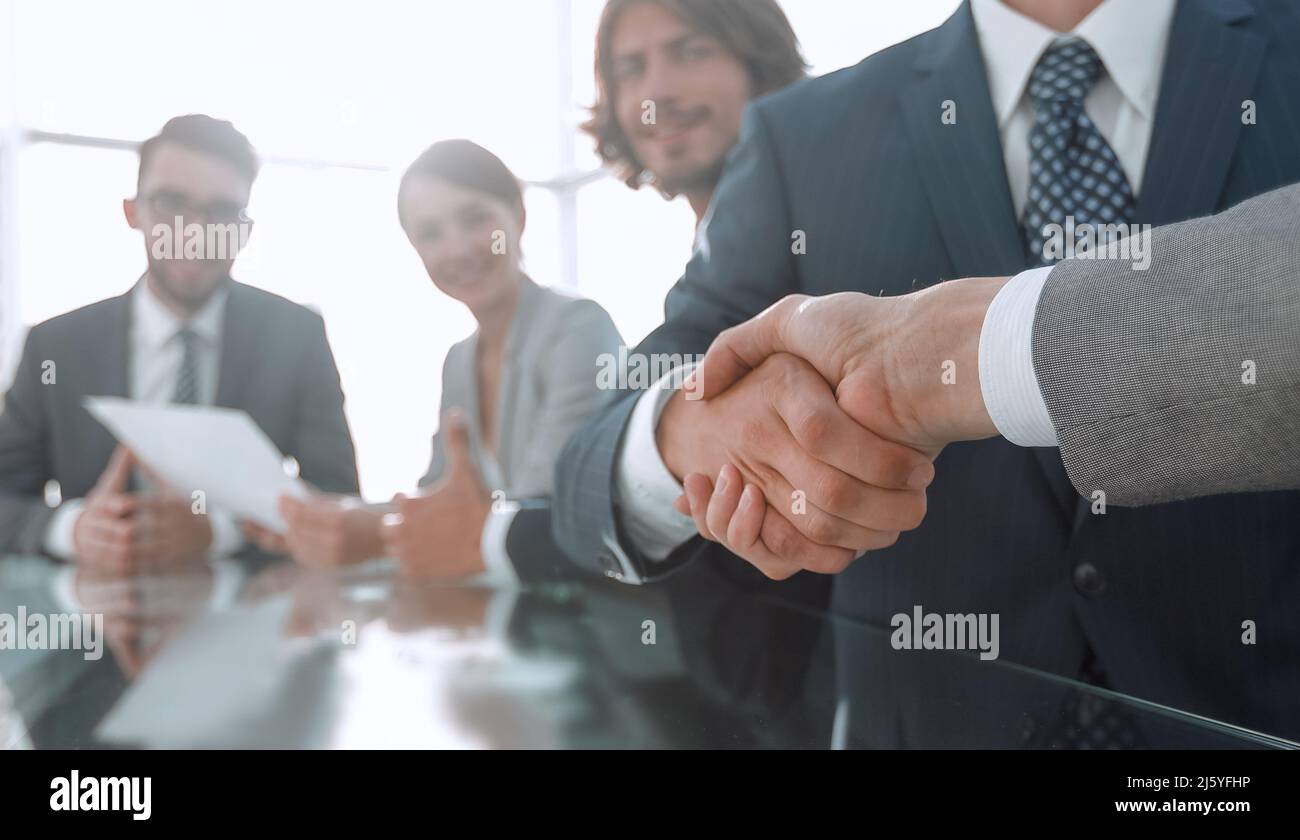 background image of handshake of business partners in conference room ...