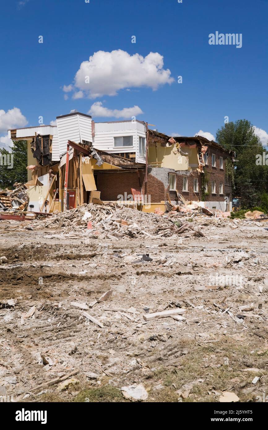 Partially demolished apartment building and lot with various debris ...