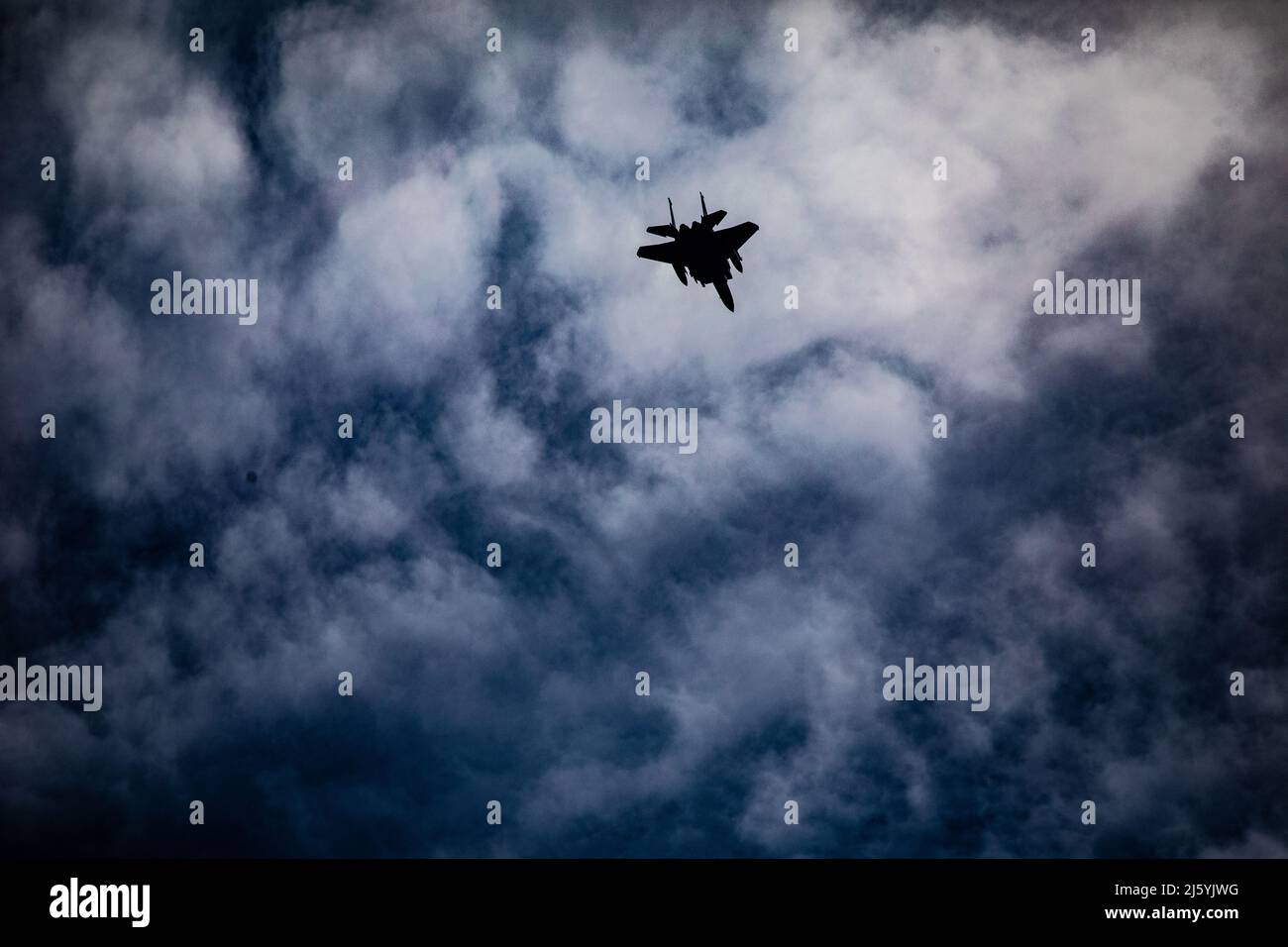 A picture of a fighter jet silhouetted against a broody sky Stock Photo ...