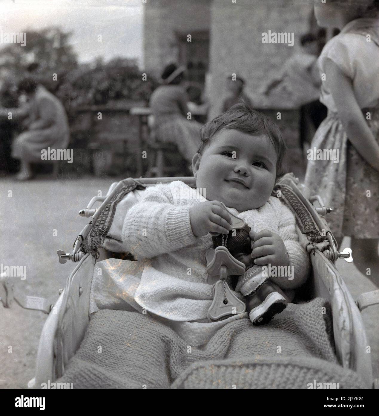 1961, historical, infant child in pushchair, old Sliver Cross, with ...