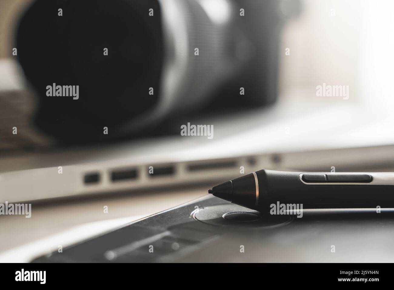 Photographer's workplace with a mirrorless camera, laptop and graphics ...
