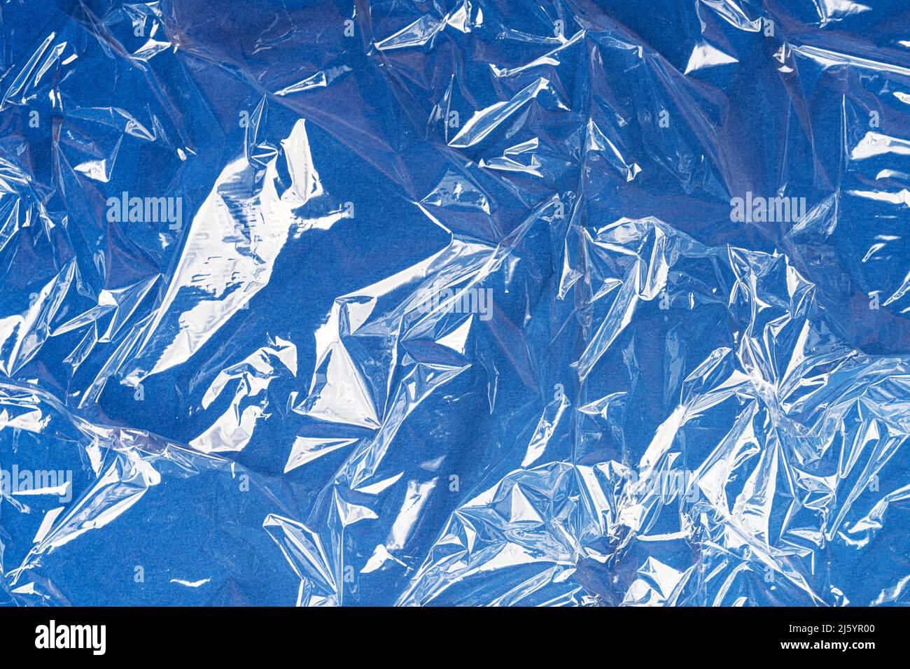 the reflections of light on a crumpled transparent plastic sheet on a ...