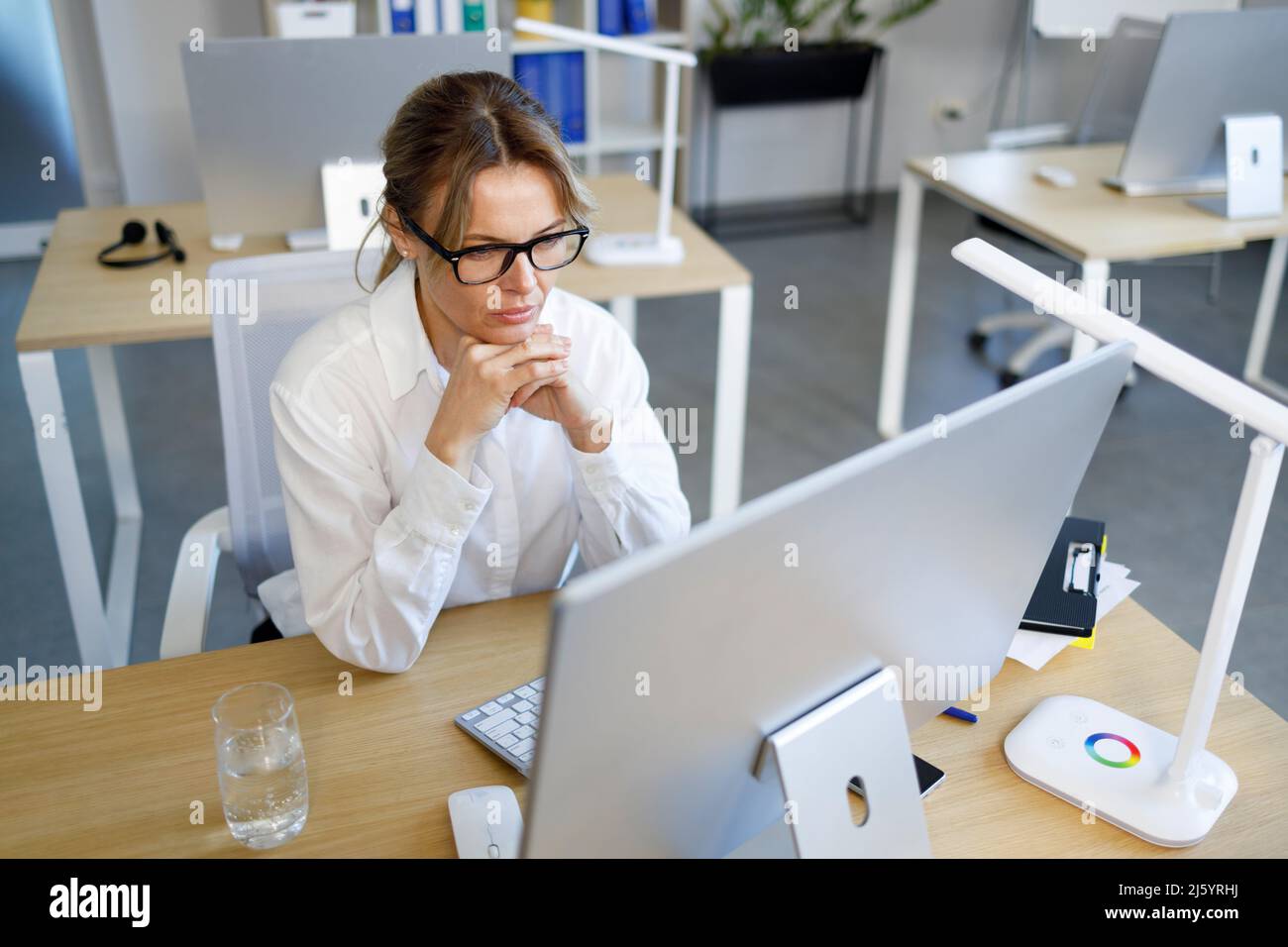 Concentrated business woman looking at computer screen Stock Photo - Alamy