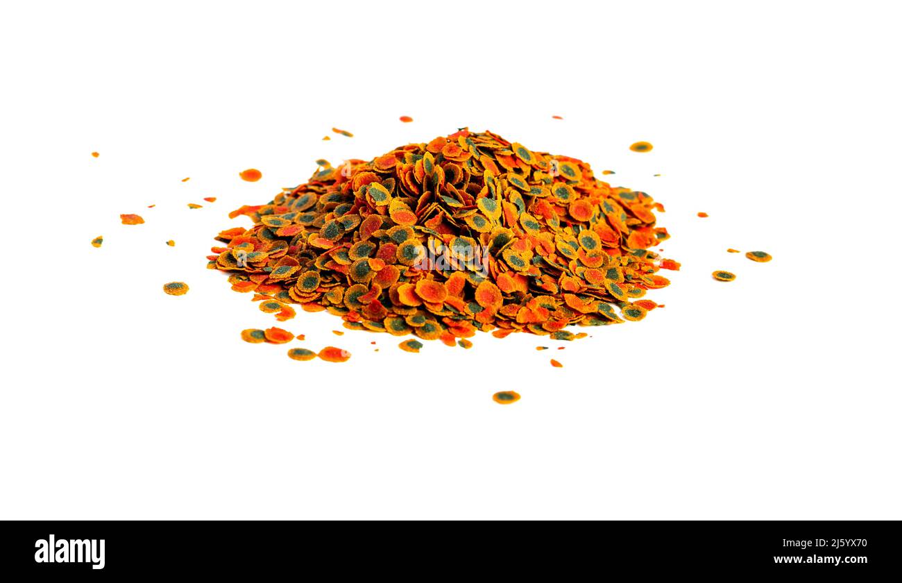 Dry handful, bunch green flakes compound fish feed flakes on White ...