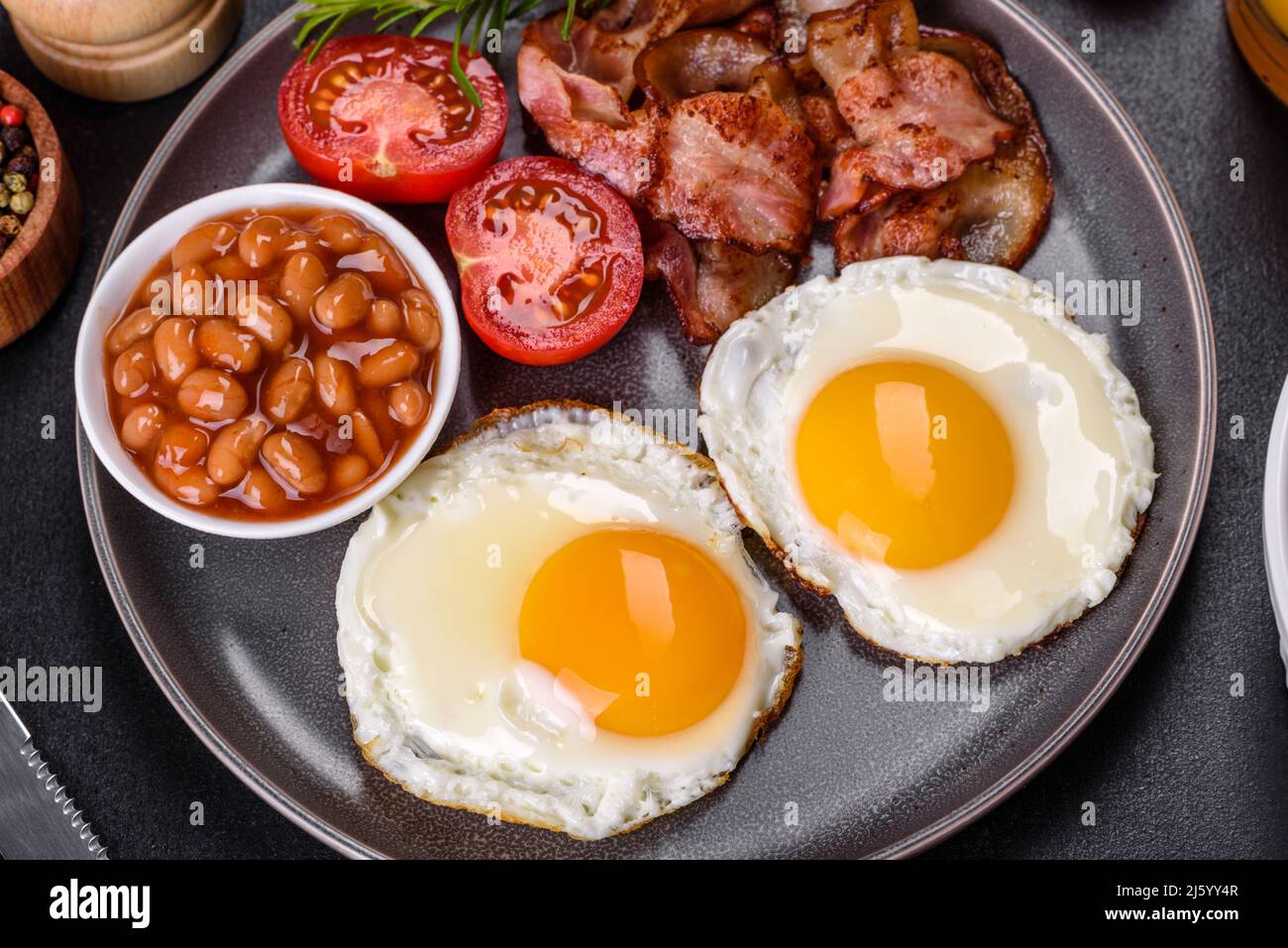 A delicious nutritious healthy breakfast with fried eggs, bacon, beans ...