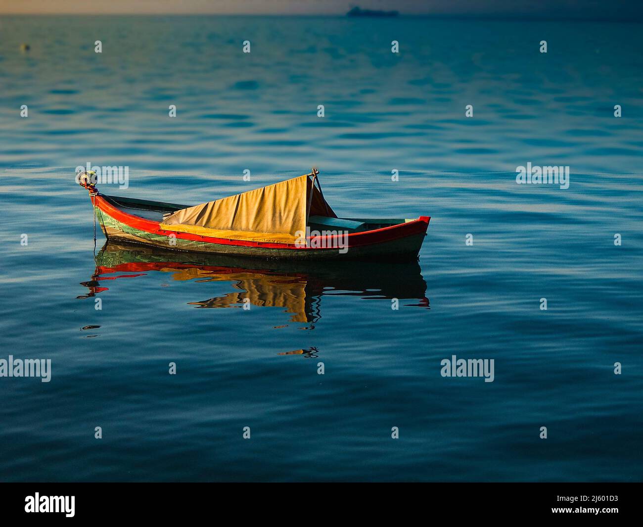 Small rowboat, with weather greenwood, red stripe, and yellow cloth ...