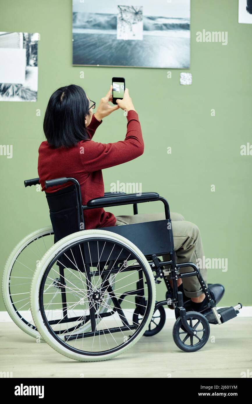 Unrecognizable Asian man with disability visiting exhibition in modern ...