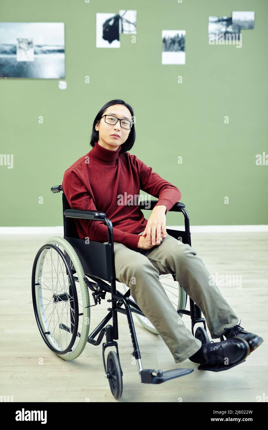 Portrait of handsome young Asian man with disability in wheelchair ...