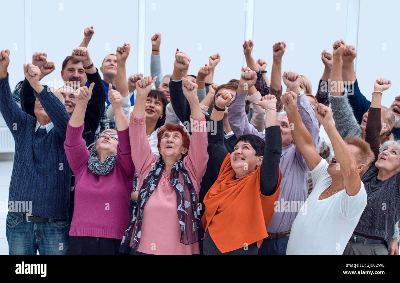 a group of elderly people raised their hands up Stock Photo - Alamy