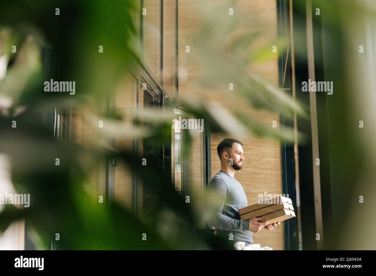 Remote view of delivery man holding boxes pizza and contactless payment ...