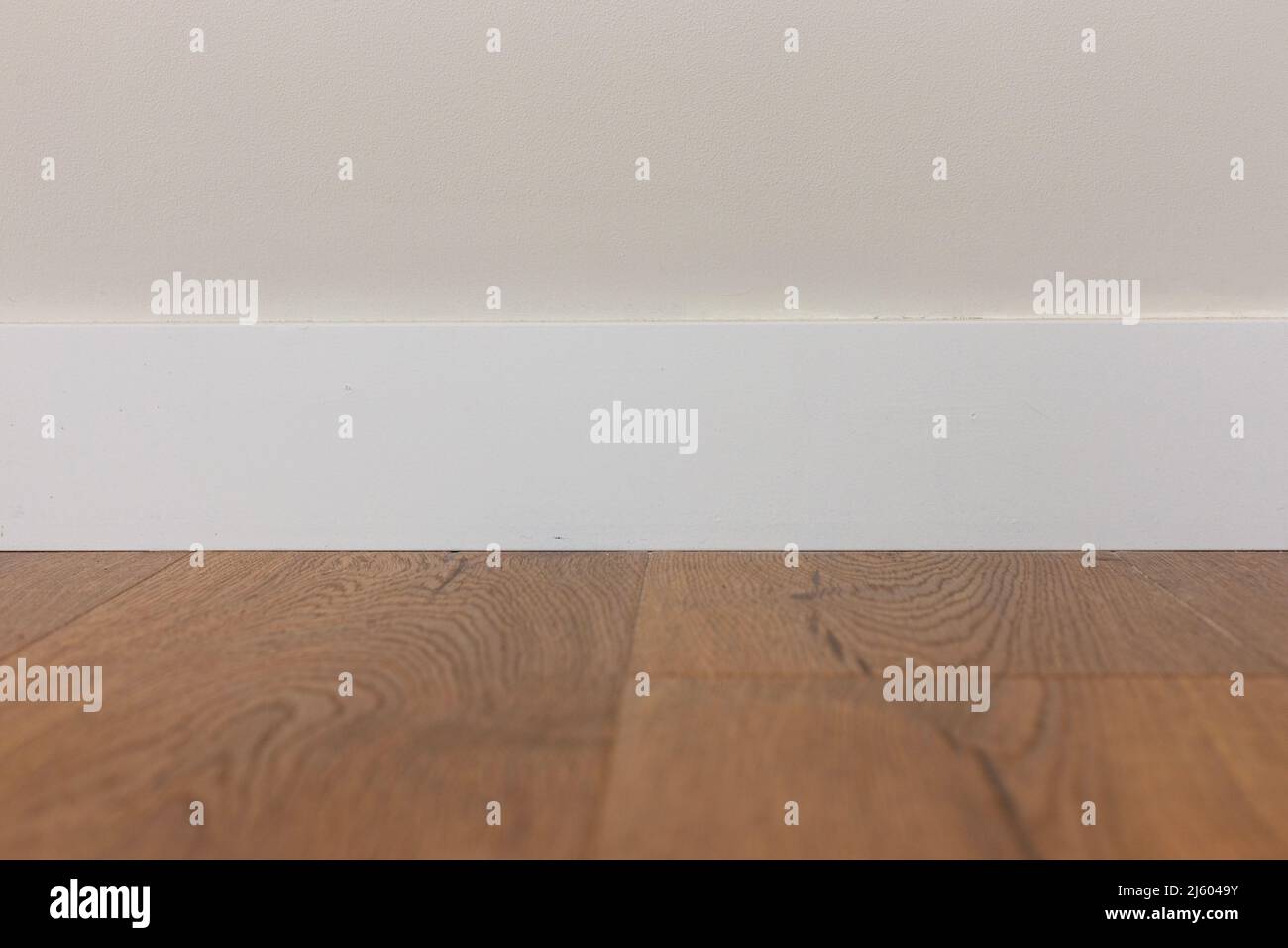 White baseboard, white wall and wood laminate Stock Photo - Alamy