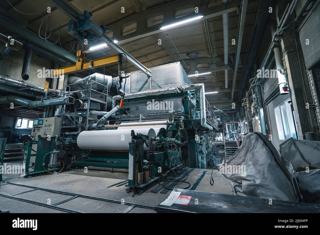 Production machine with rolls of new paper in waste paper recycling ...