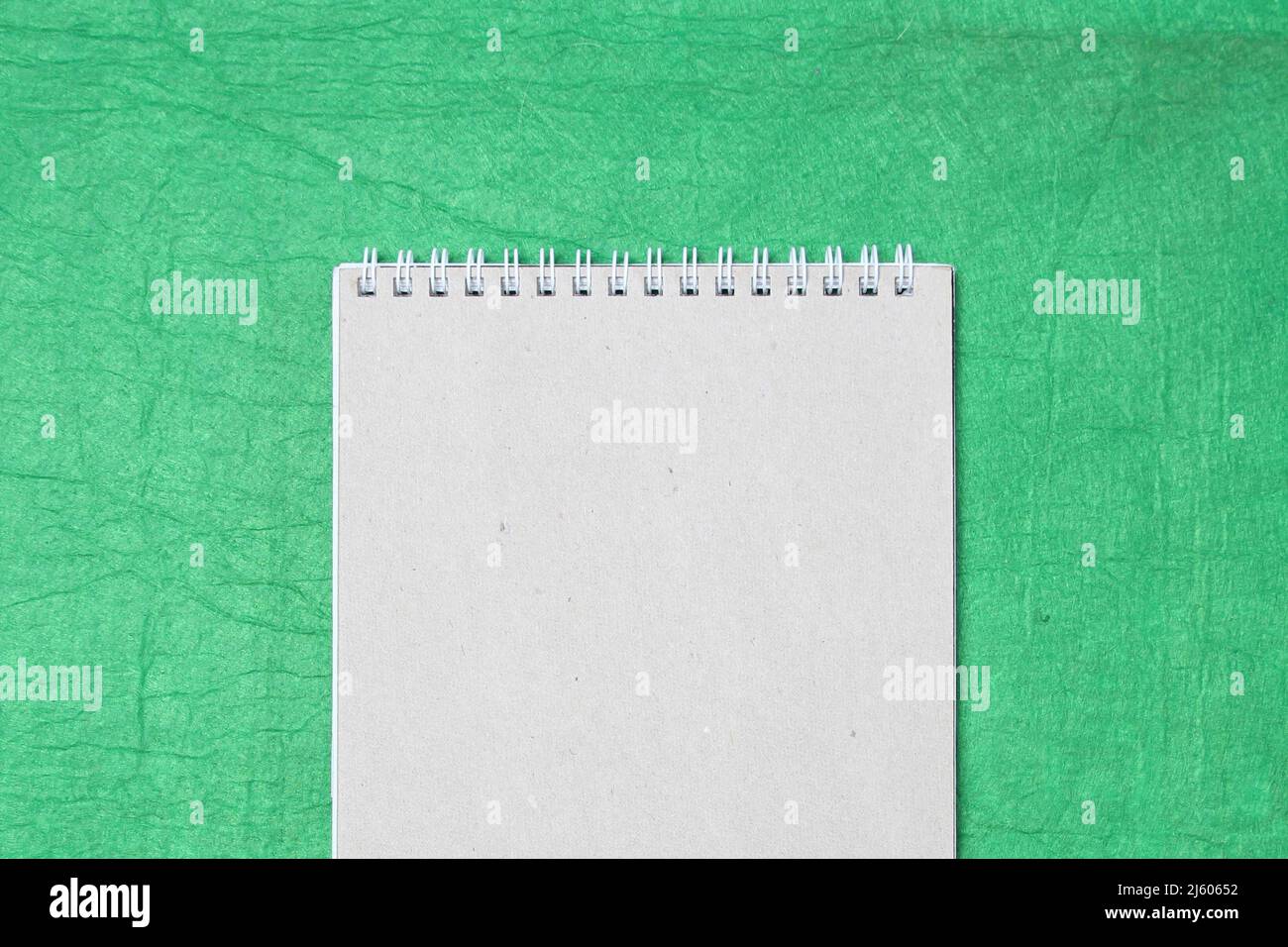 White and gray notepad sheet with spiral against the background of ...