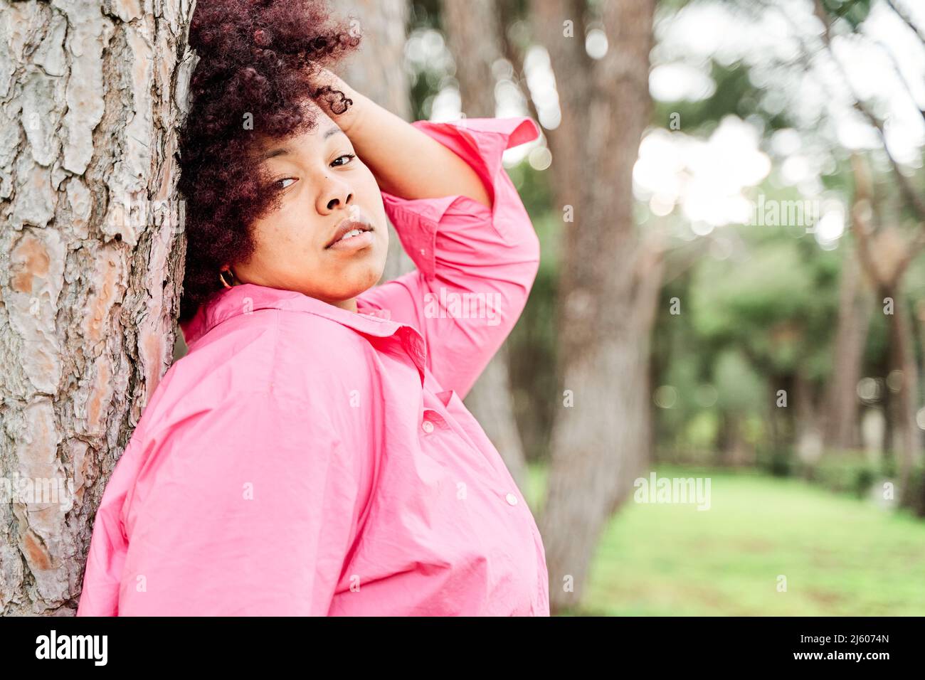 Portrait Of A Curly Haired African American Woman Leaning Against A