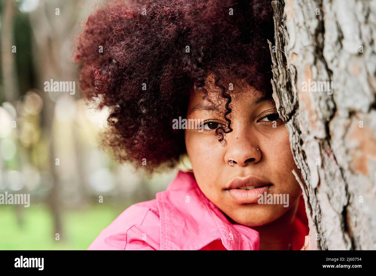 Portrait Of A Curly Haired African American Woman Leaning Against A