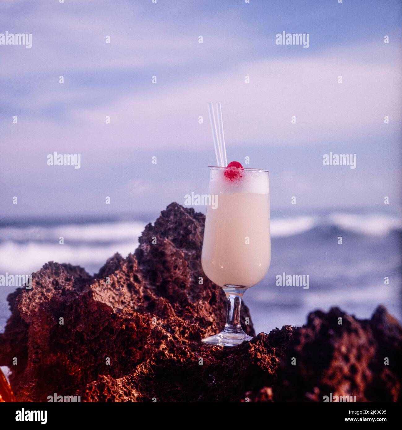 Drinks still-life of Piña Colada with cherry garnish on the rocks with ...