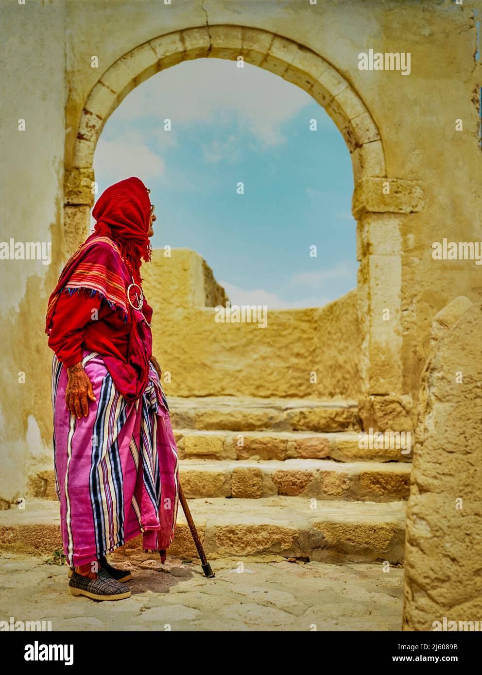 Hale and hearty mature woman in national dress with cane and head ...