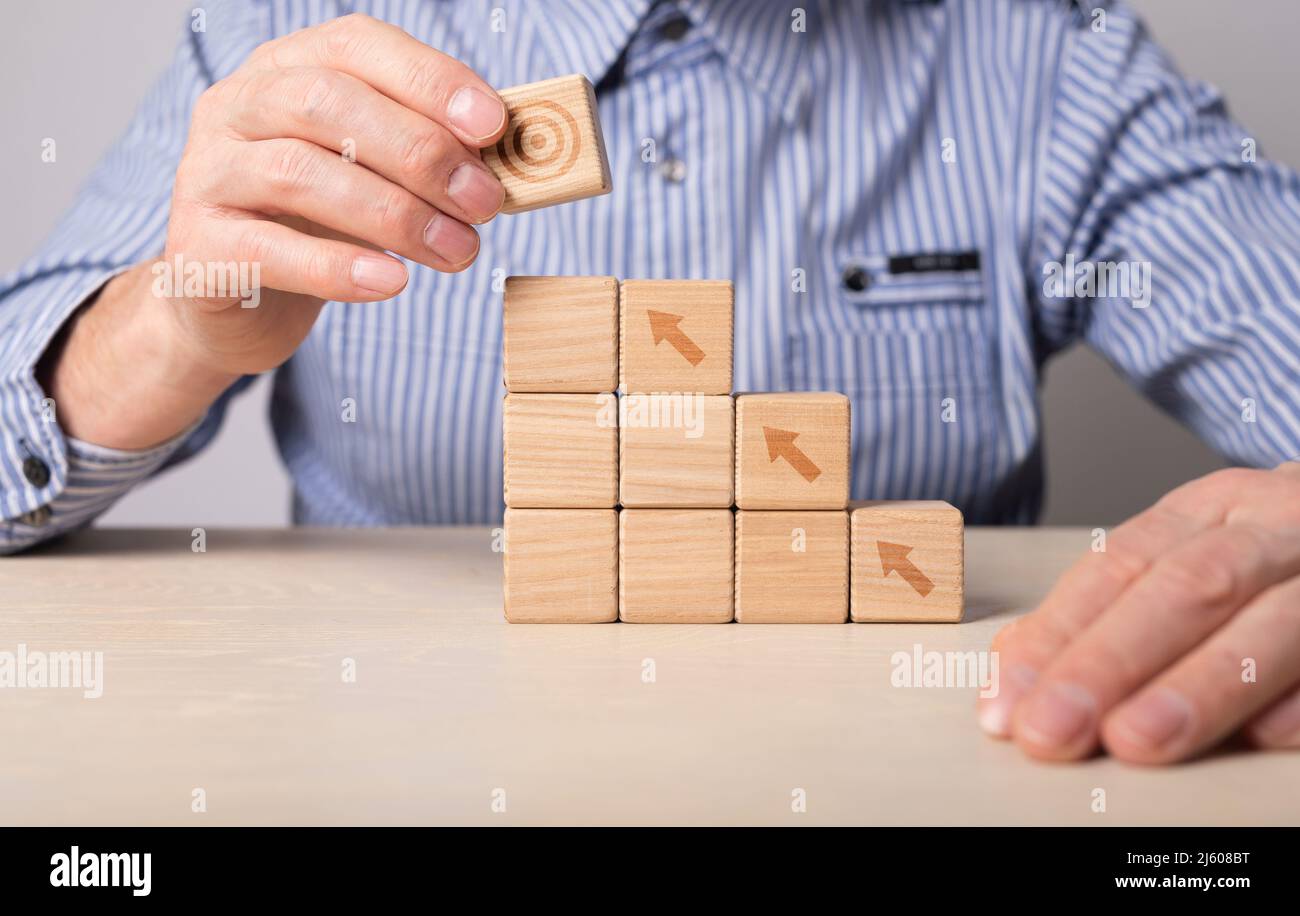 Man building career ladder from wooden blocks with arrows. Business ...