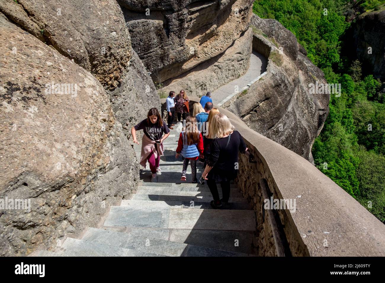 People climbing stairs cut in a rock to Varlaam (Agioi Pantes ...