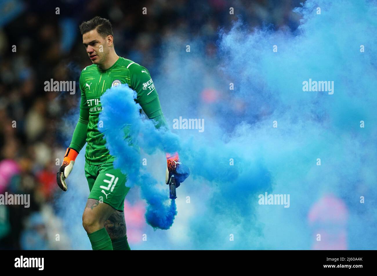 Manchester City goalkeeper Ederson clears a flare of the pitch after ...