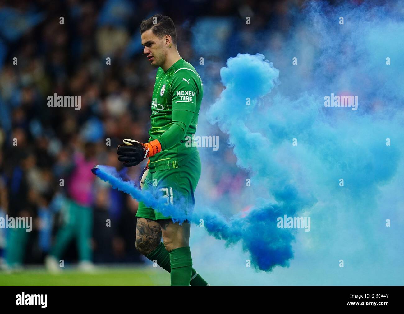 Manchester City goalkeeper Ederson clears a flare of the pitch after ...